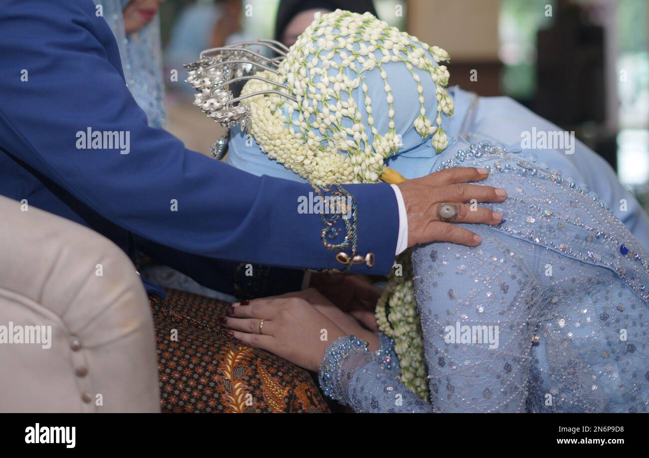 Bride and Groom Kneeing on Parents Lap in Traditional Wedding Ceremony ...