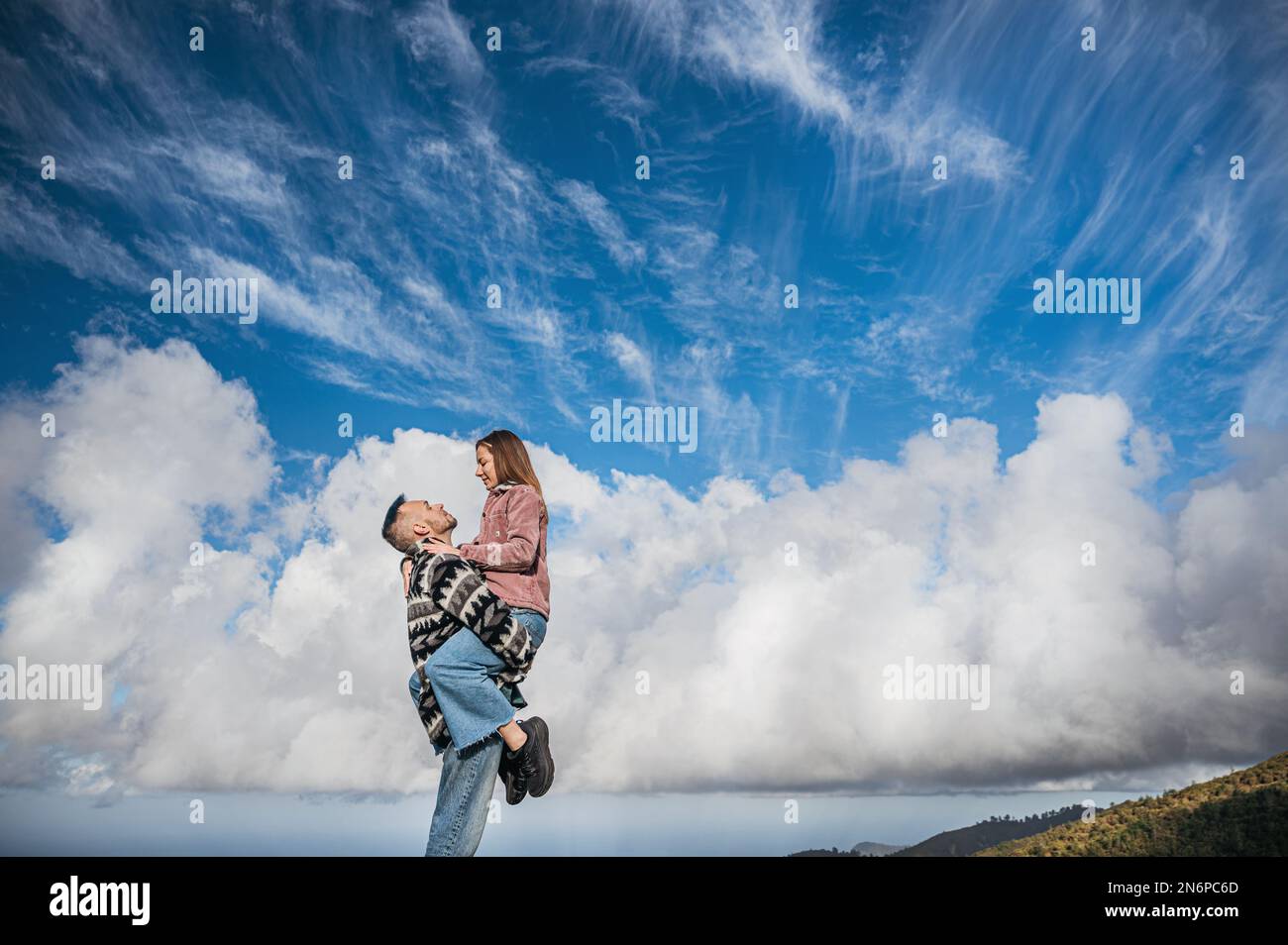 Couple In A Stunning Landscape Man Holds The Woman As She Wraps Her Arms And Legs Around Him