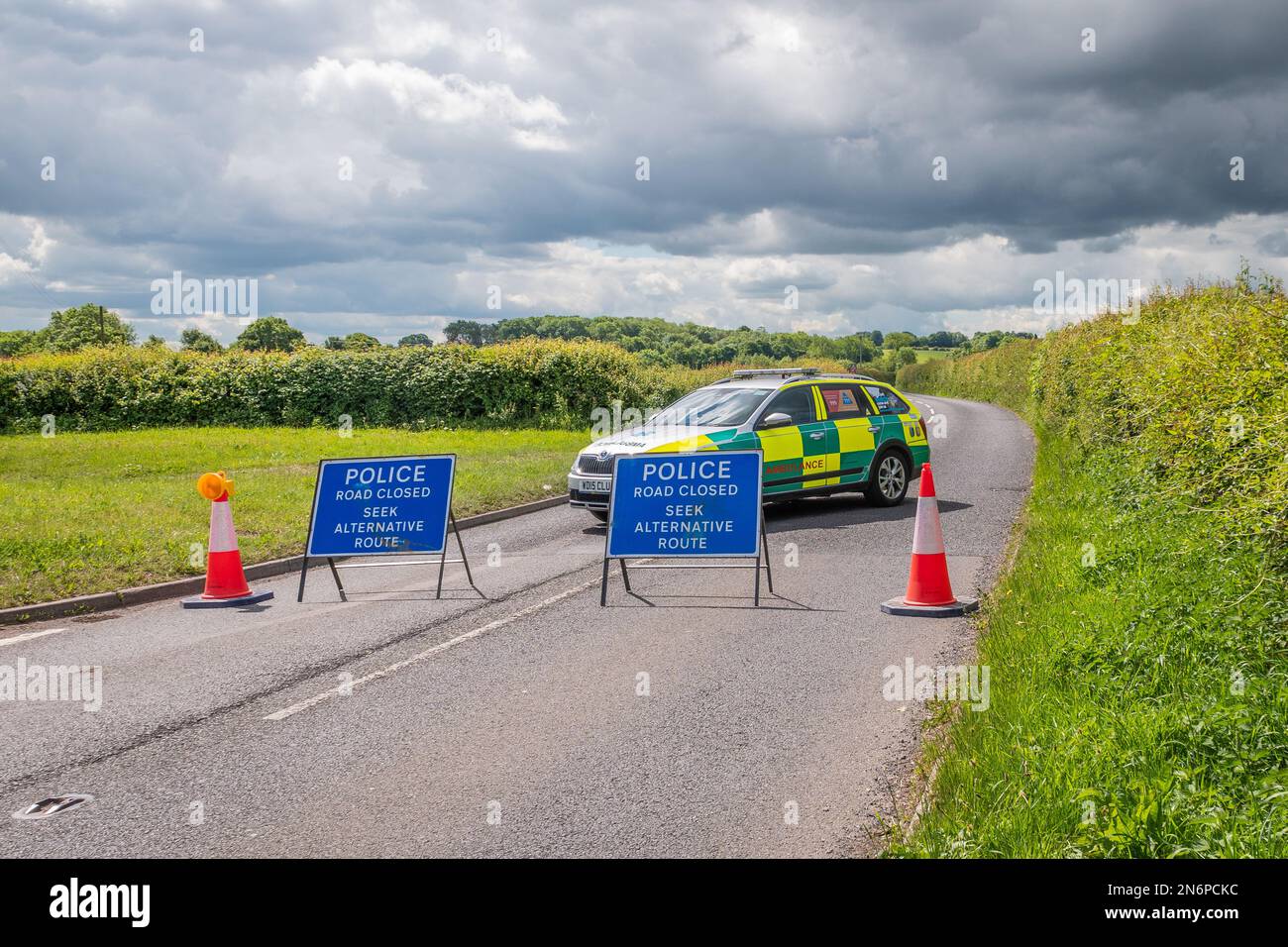 2 blue police road signs marking a road as closed with orange traffic ...