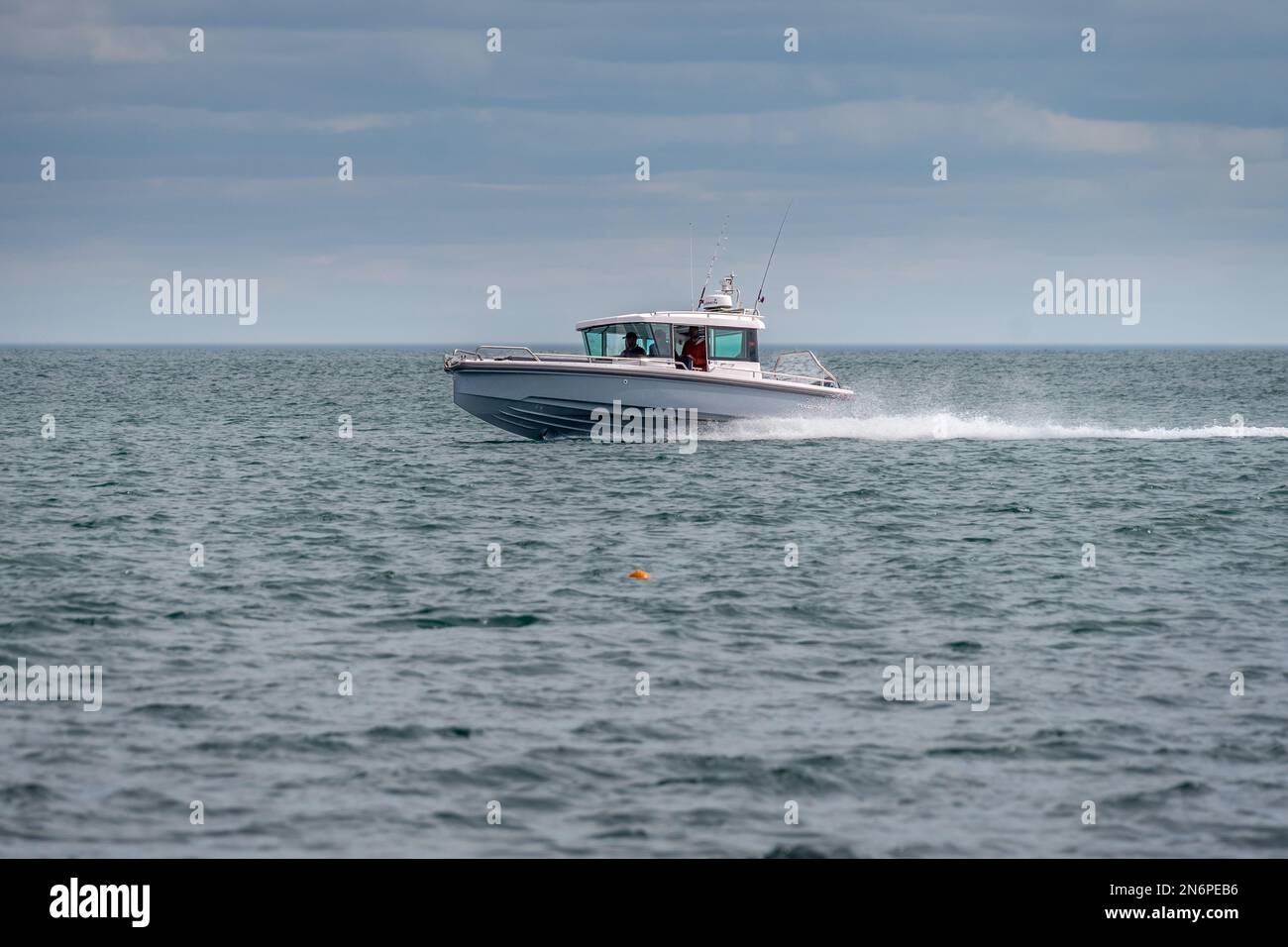 A small motor fishing boat travelling across the sea in the bay at ...