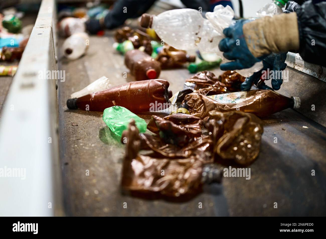 Worker sorts trash on conveyor belt at waste recycling plant Stock Photo - Alamy