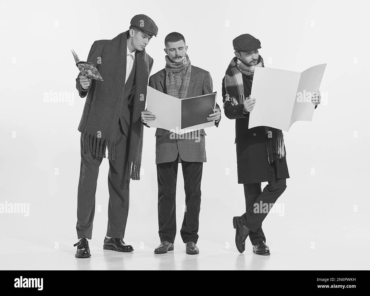 Portrait of stylish men reading magazines and newspapers isolated over ...