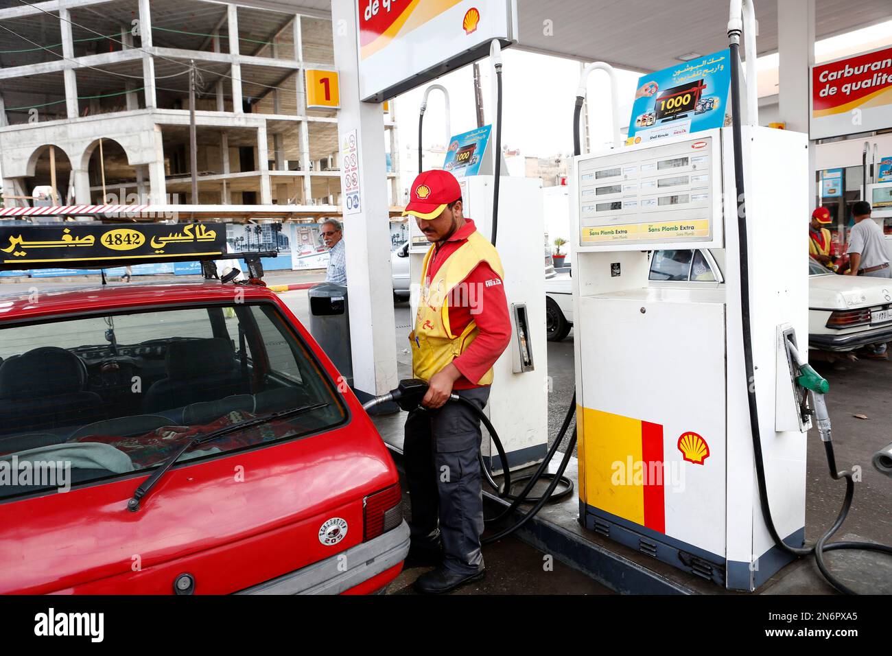A Moroccan gas station attendant pumps gasoline into customer’s car at ...