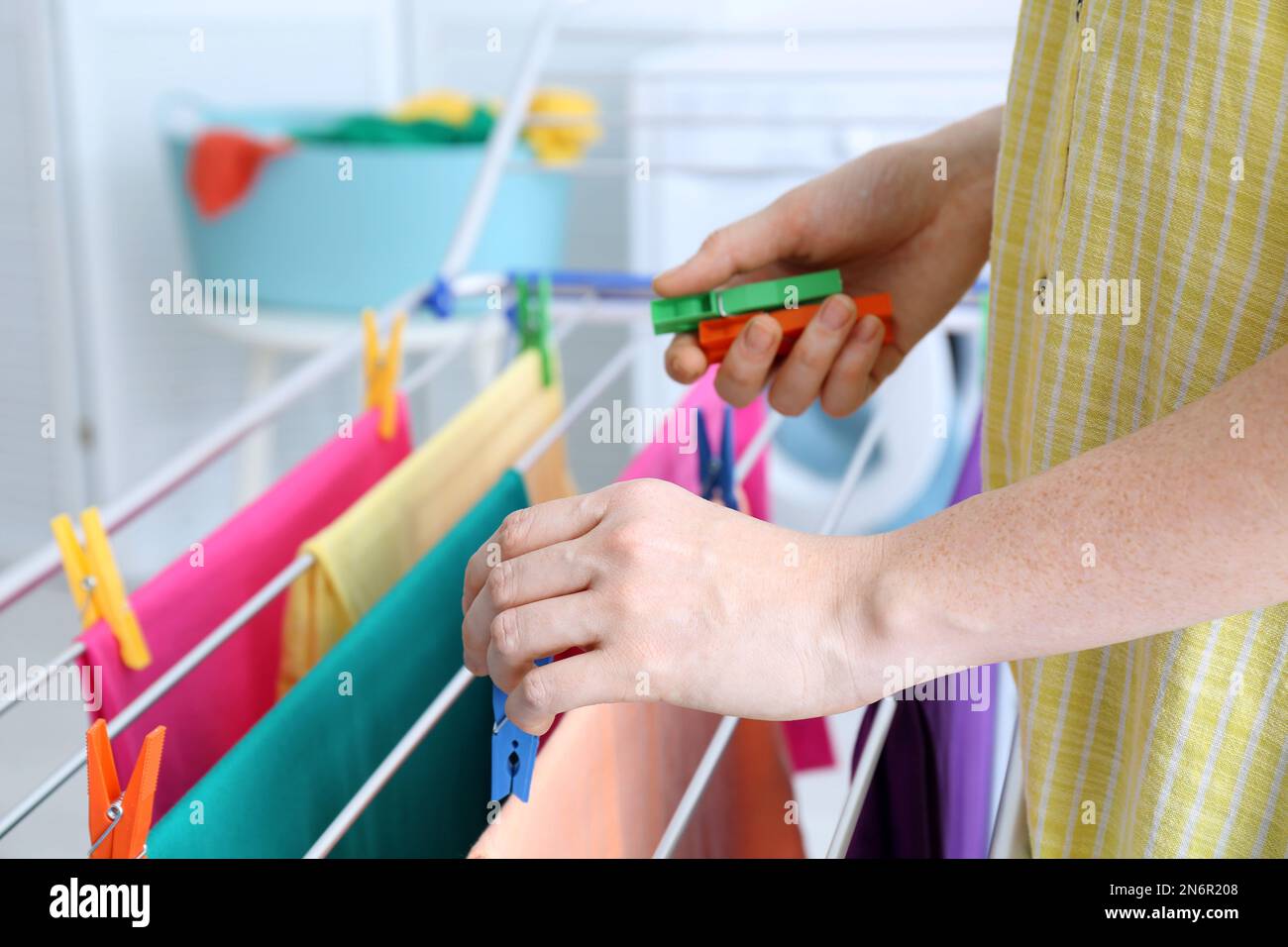 Woman hanging clean laundry on drying rack indoors, closeup Stock Photo ...