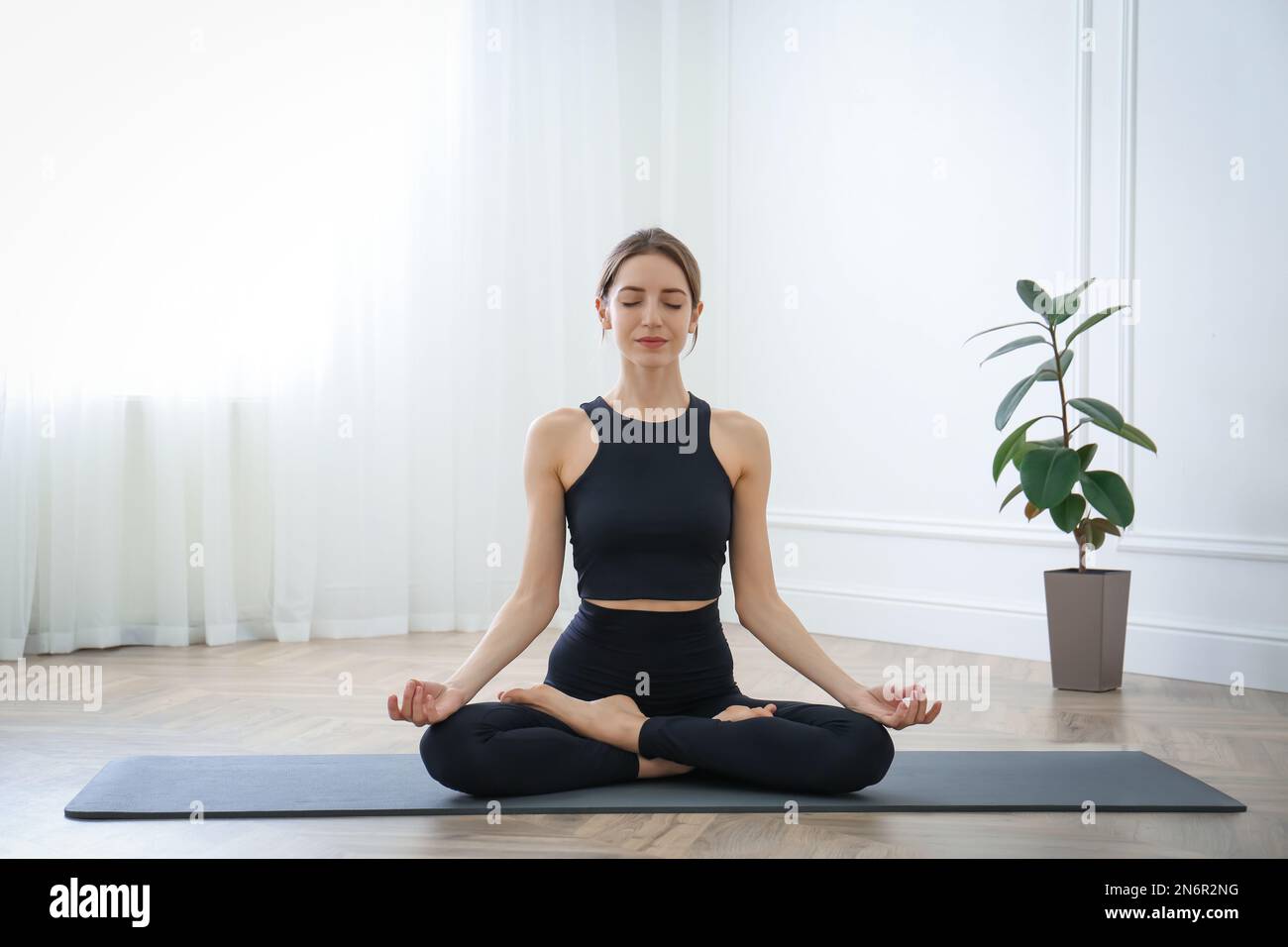Young woman practicing lotus asana in yoga studio. Padmasana pose Stock ...