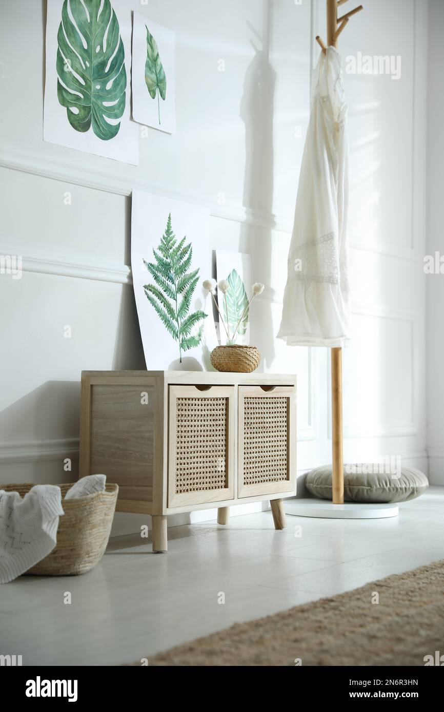 Wooden commode near white wall in room. Interior design Stock Photo - Alamy