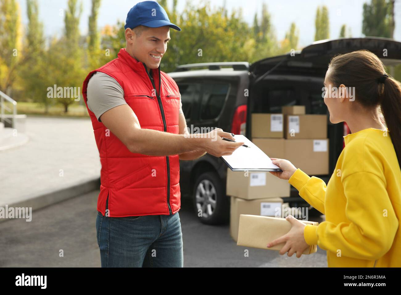 Courier receiving receipt signature from customer outdoors Stock Photo ...