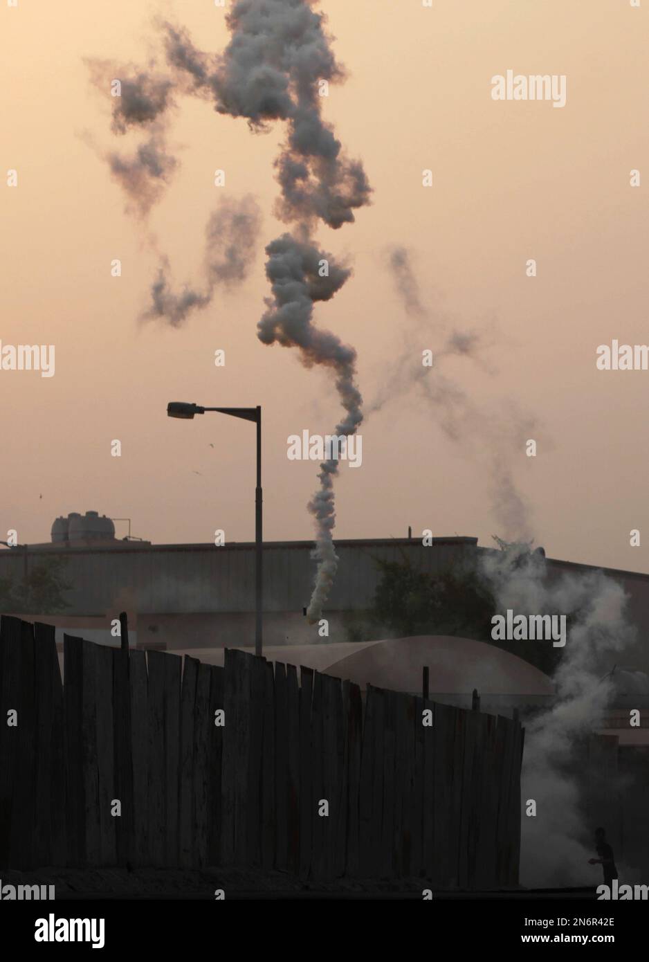 A Bahraini anti-government protester confronts with riot police firing ...
