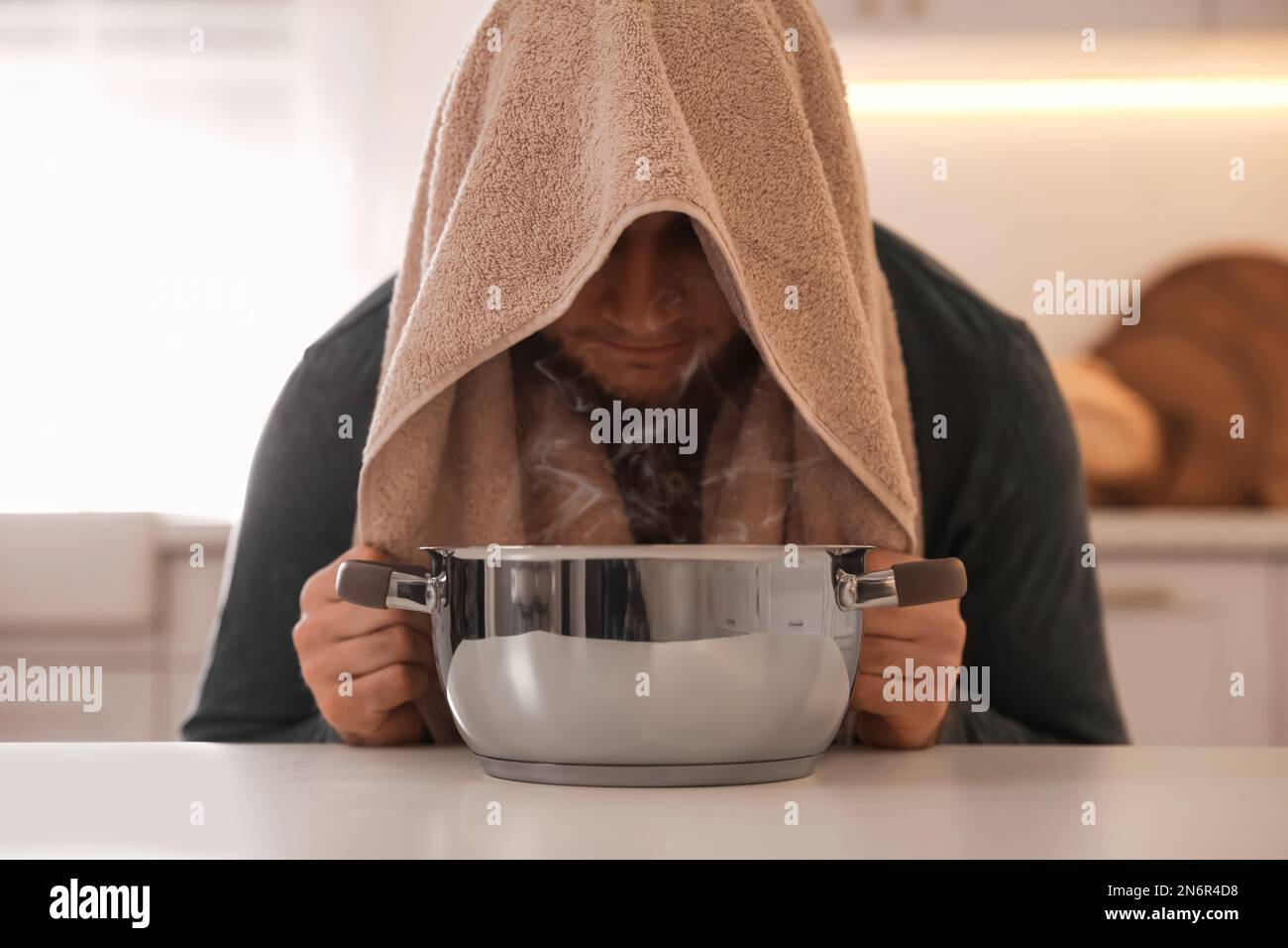 Man taking treatments at table indoors. Steam inhalation Stock Photo ...