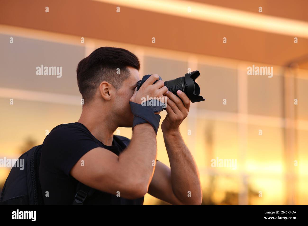 Photographer taking picture with professional camera on city street at ...