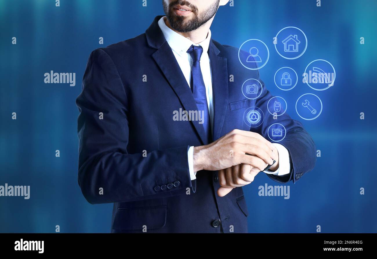 Businessman with modern smartwatch on blue background Stock Photo - Alamy