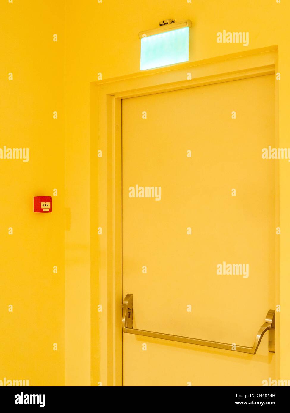 closed emergency fire exit in building illuminated by yellow light ...