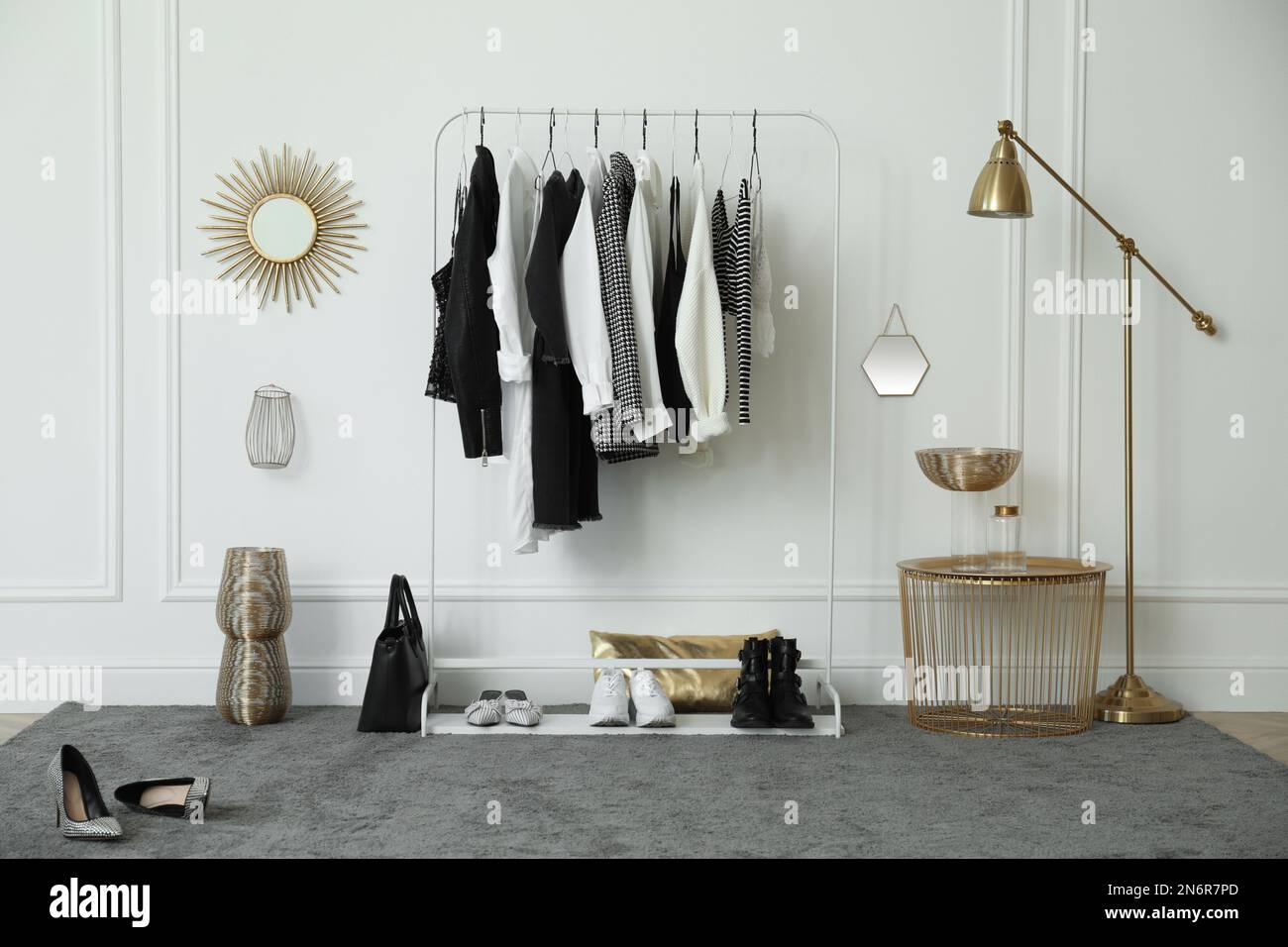 Rack with stylish clothes near white wall in dressing room Stock Photo ...