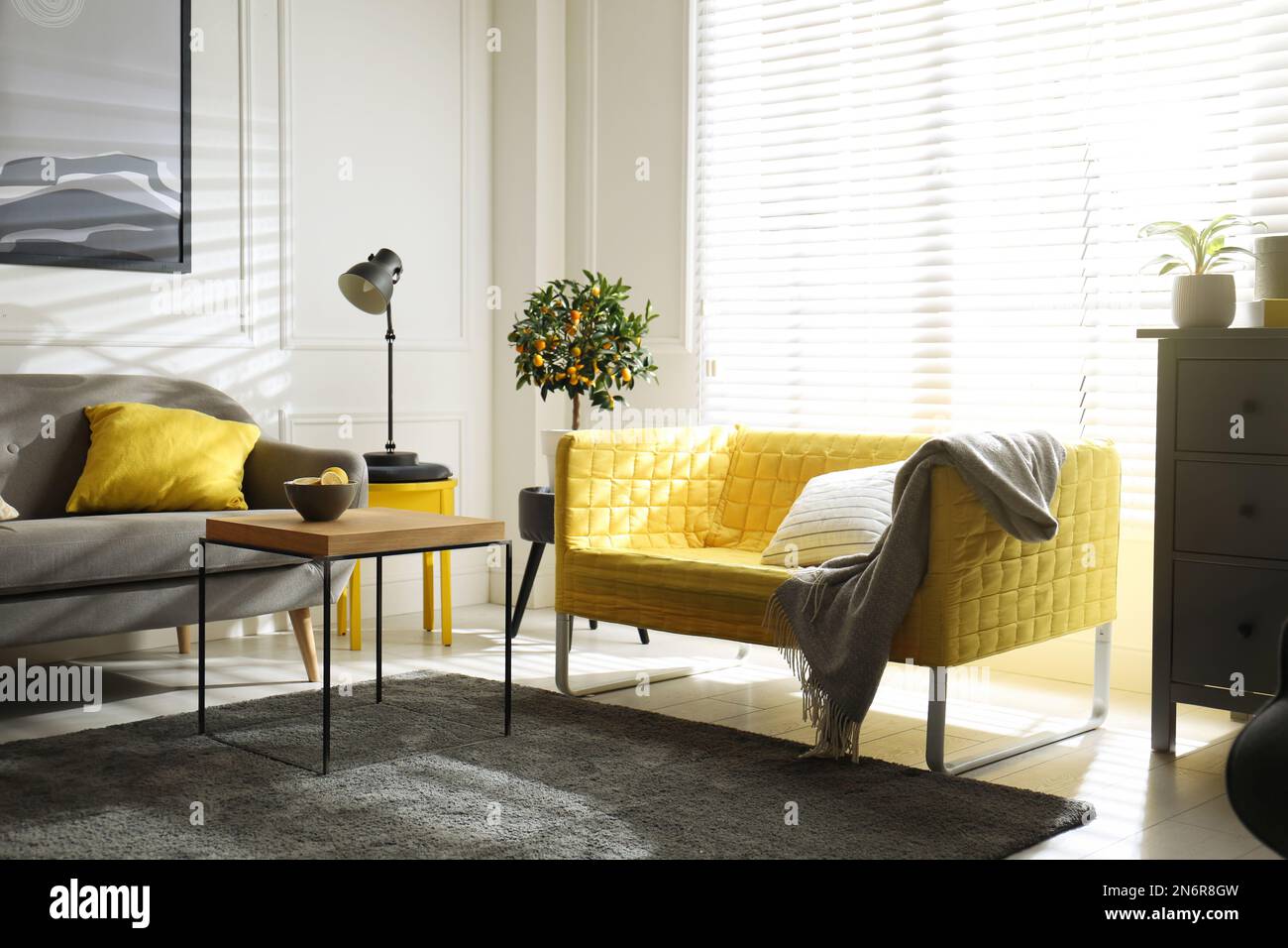 Stylish living room with sofas. Interior design in grey and yellow ...
