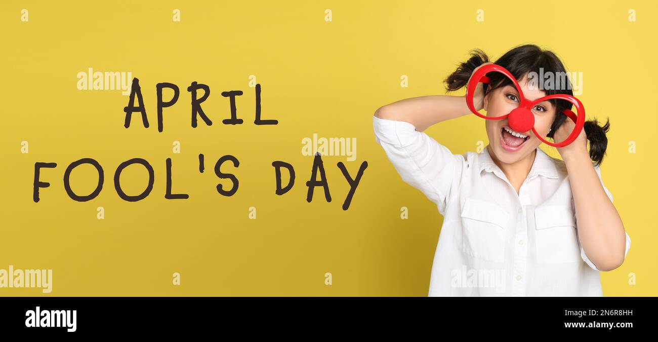 Funny woman with large glasses and clown nose on yellow background ...