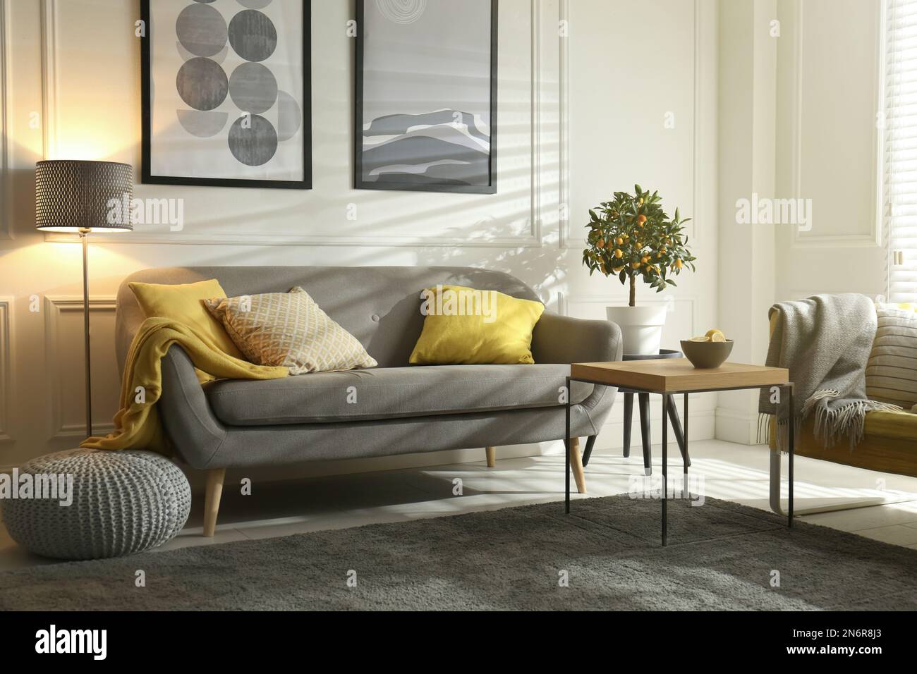 Stylish living room with sofa. Interior design in grey and yellow ...