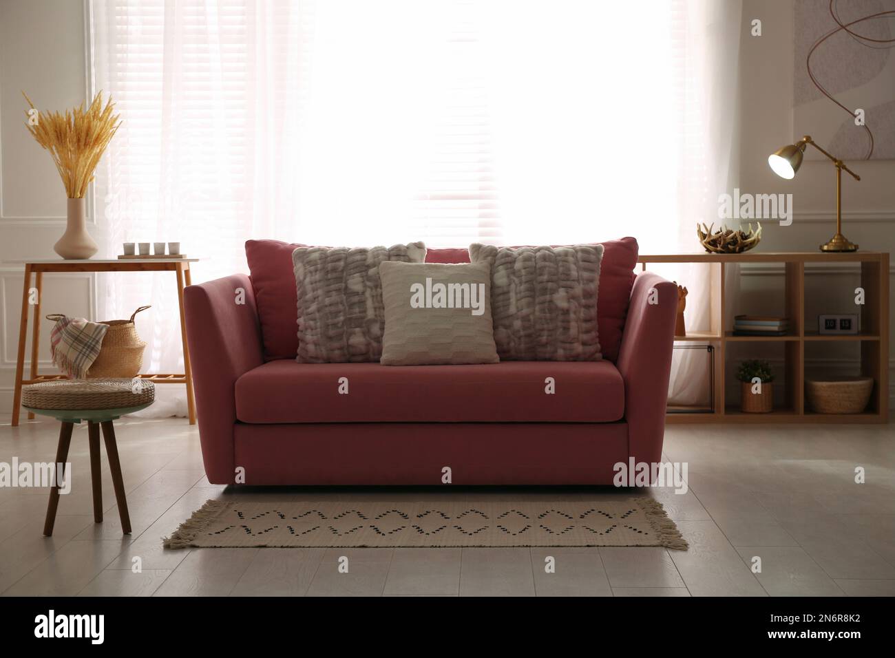 Stylish living room interior with comfortable red sofa and cushions ...