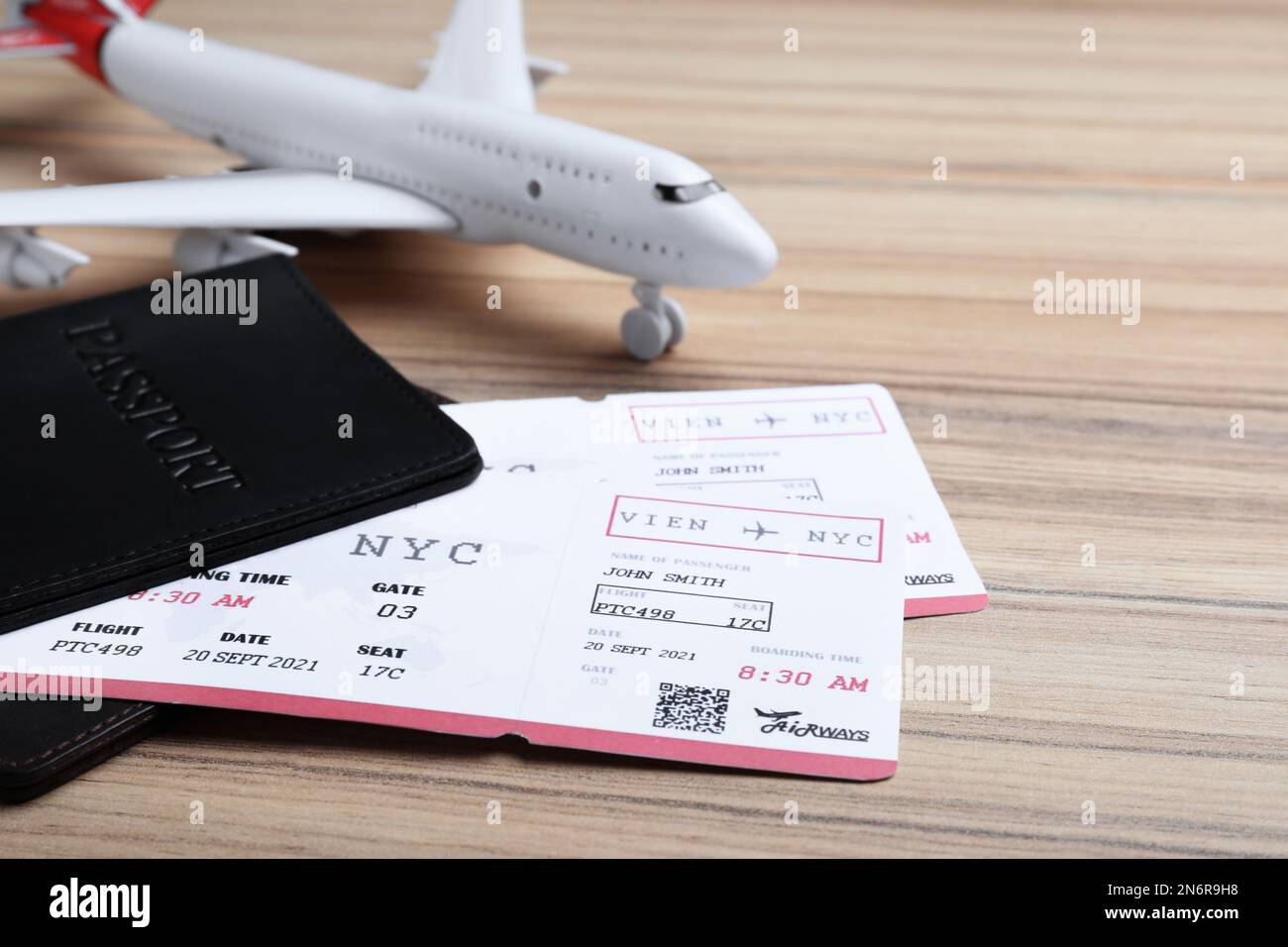 Avia tickets, passports and plane on wooden table, closeup. Travel agency concept Stock Photo ...