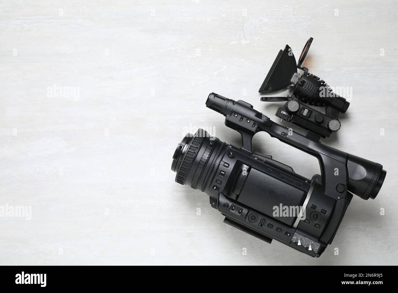 Modern video camera with flashlight on light grey background, top view ...