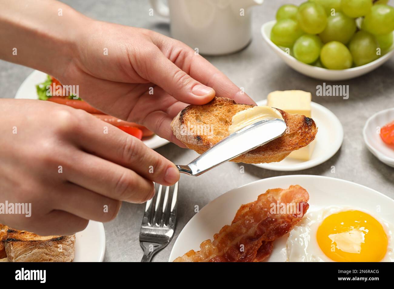 Woman spreading butter on toast at table, closeup. Buffet service Stock ...