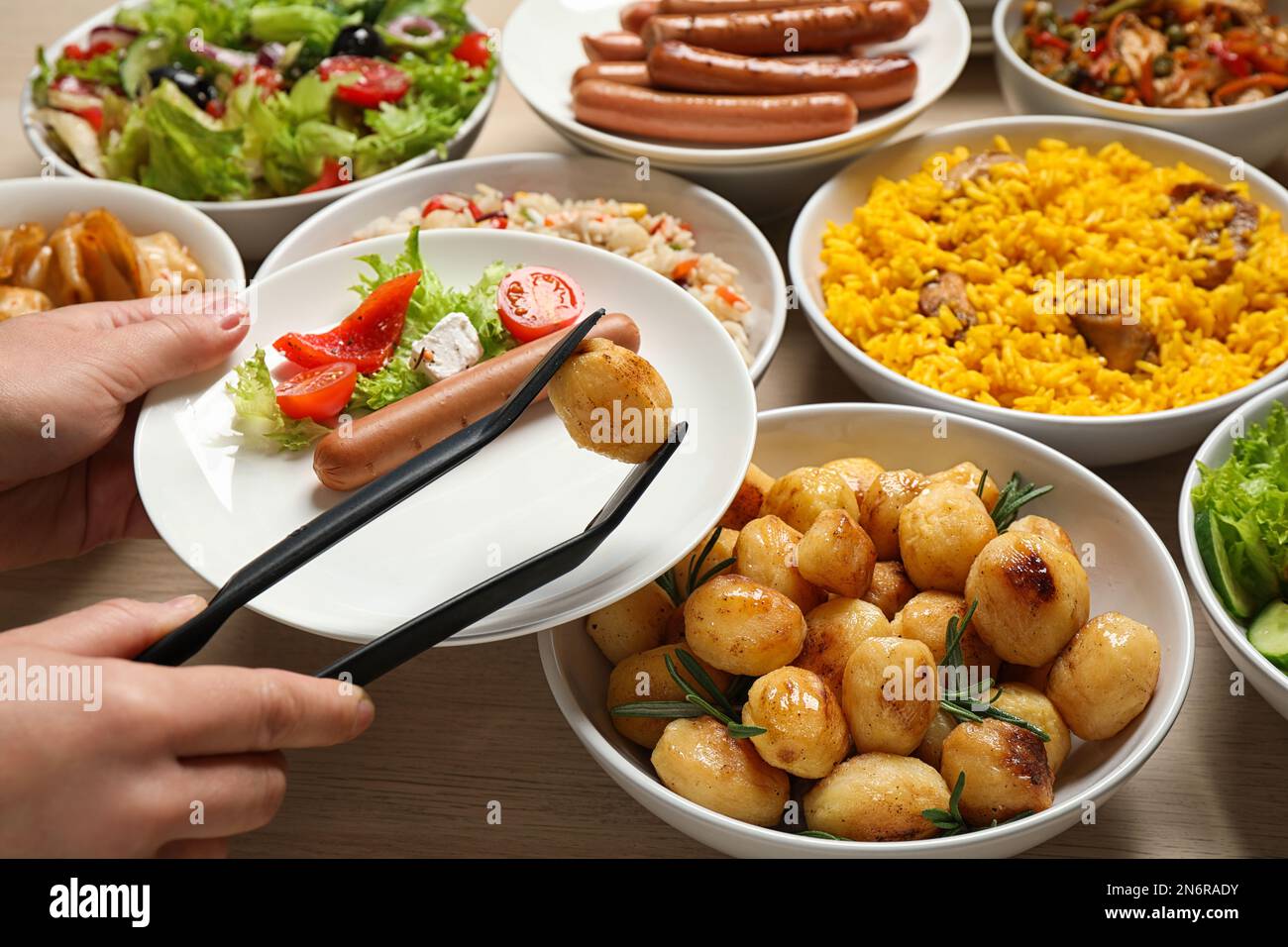 Woman taking food from buffet table, closeup Stock Photo - Alamy