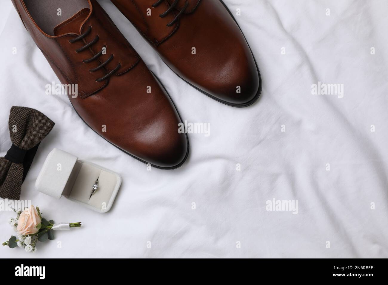 Flat lay composition with wedding shoes on white fabric, space for text ...