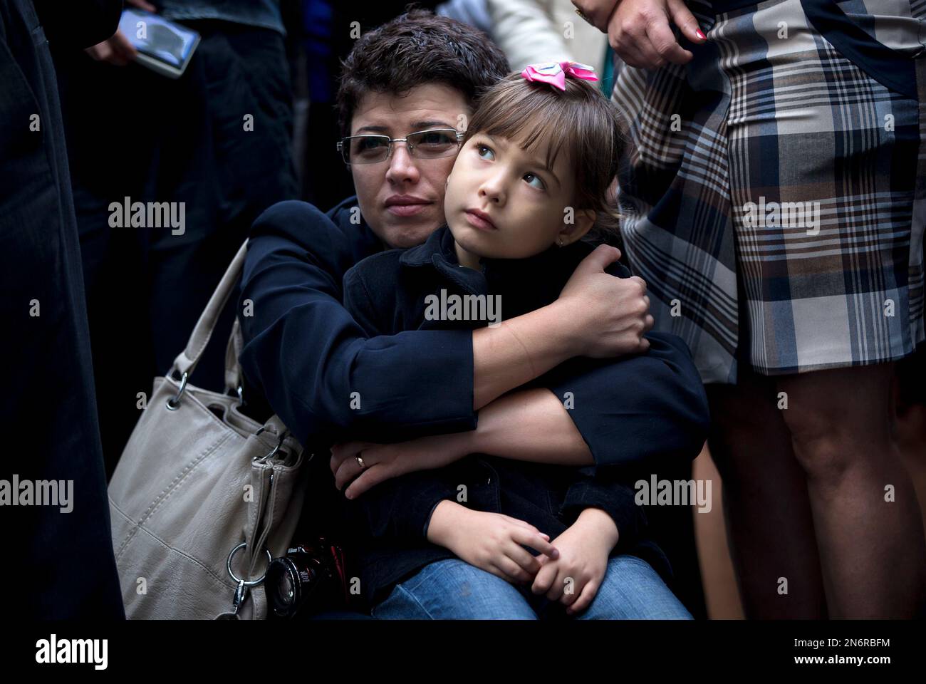 A woman holds a child during an opening ceremony at a former military ...