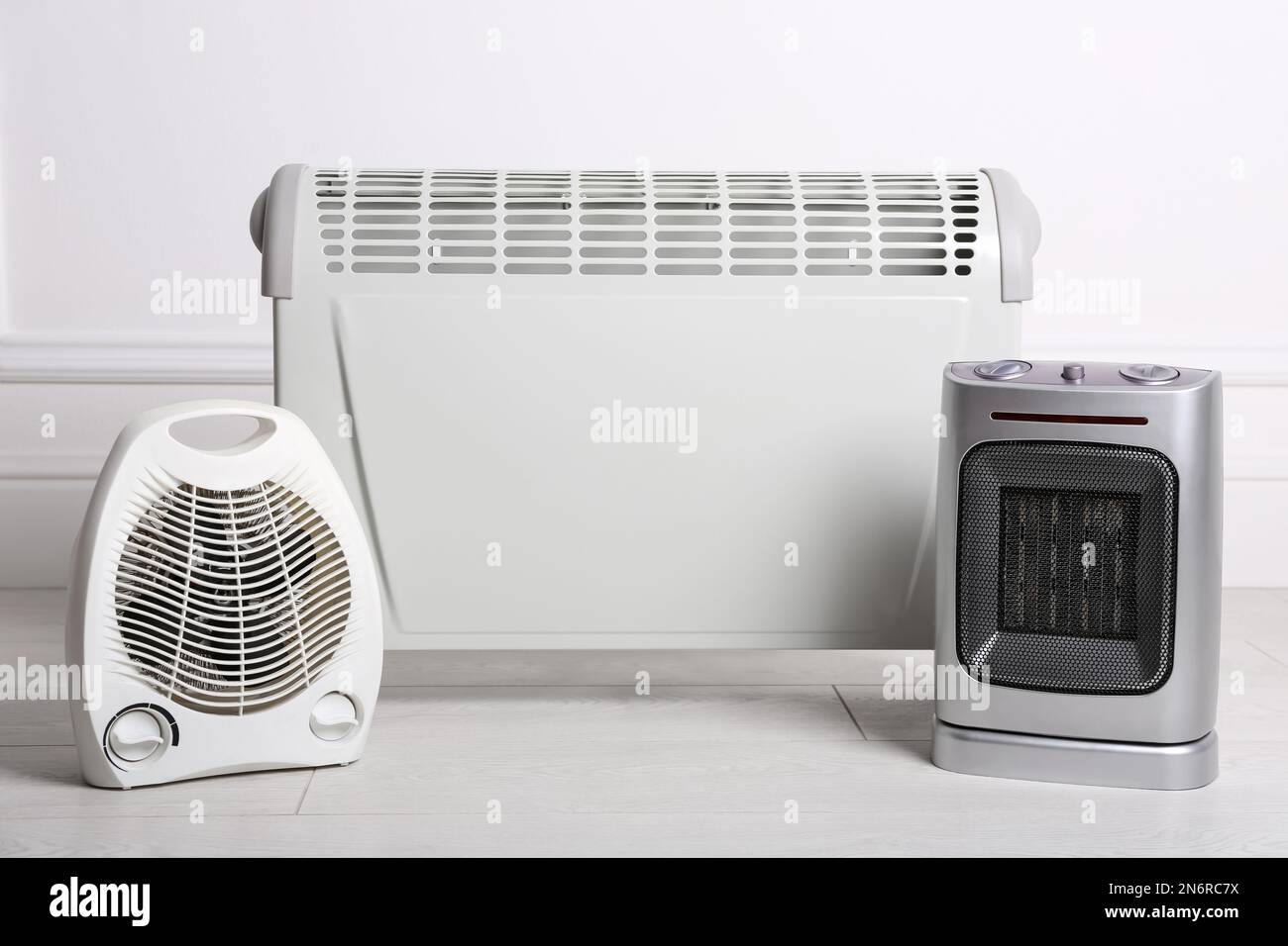 Three different electric heaters on floor in room Stock Photo - Alamy