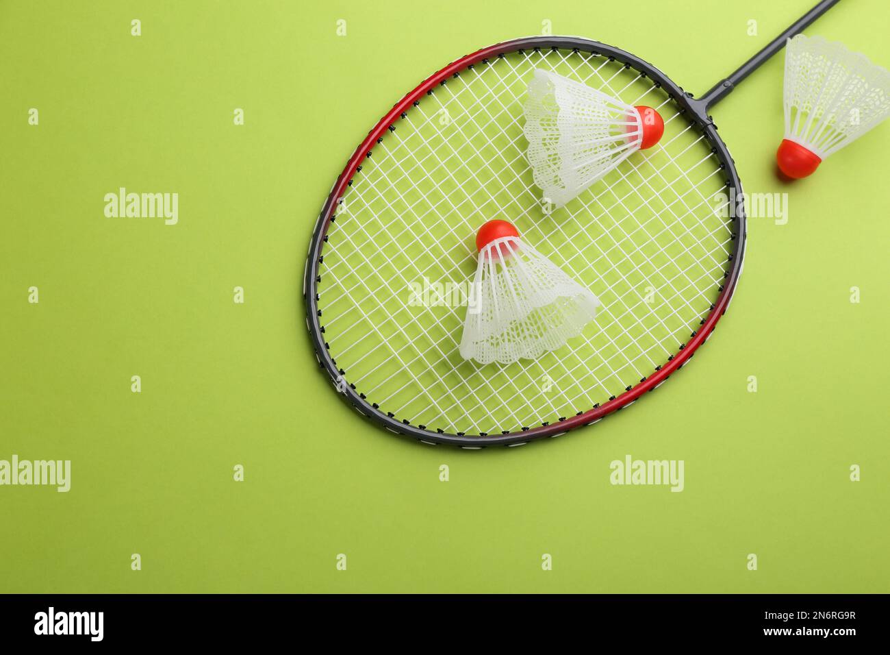 Badminton racket and shuttlecocks on light green background, flat lay ...