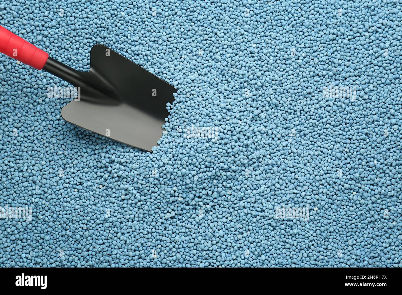 Shovel and granular mineral fertilizer, top view with space for text ...