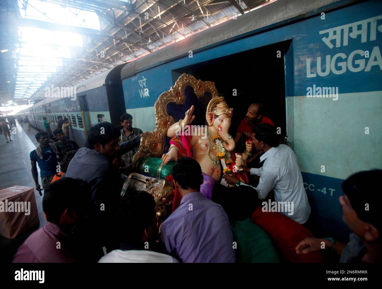 A clay idol of elephant headed Hindu god Ganesh is carried onto a ...