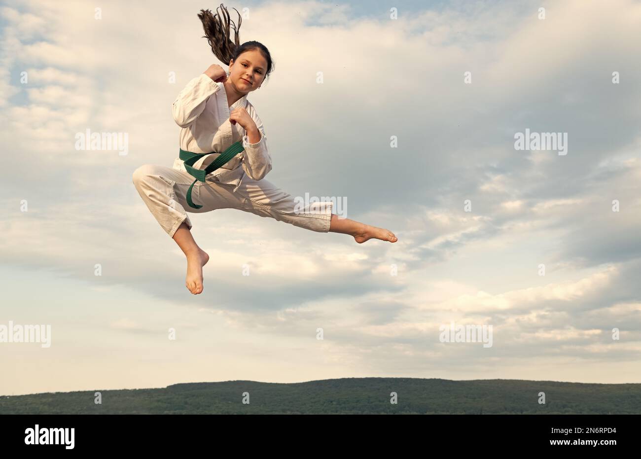 karate girl in kimono jump on sky background Stock Photo - Alamy