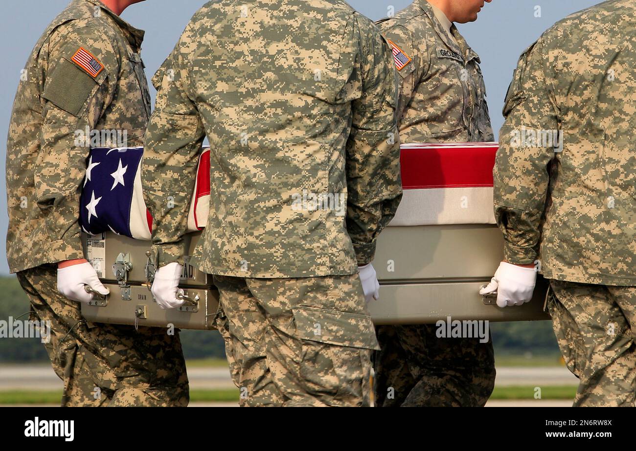 An Army carry team carries the transfer case containing the remains of ...