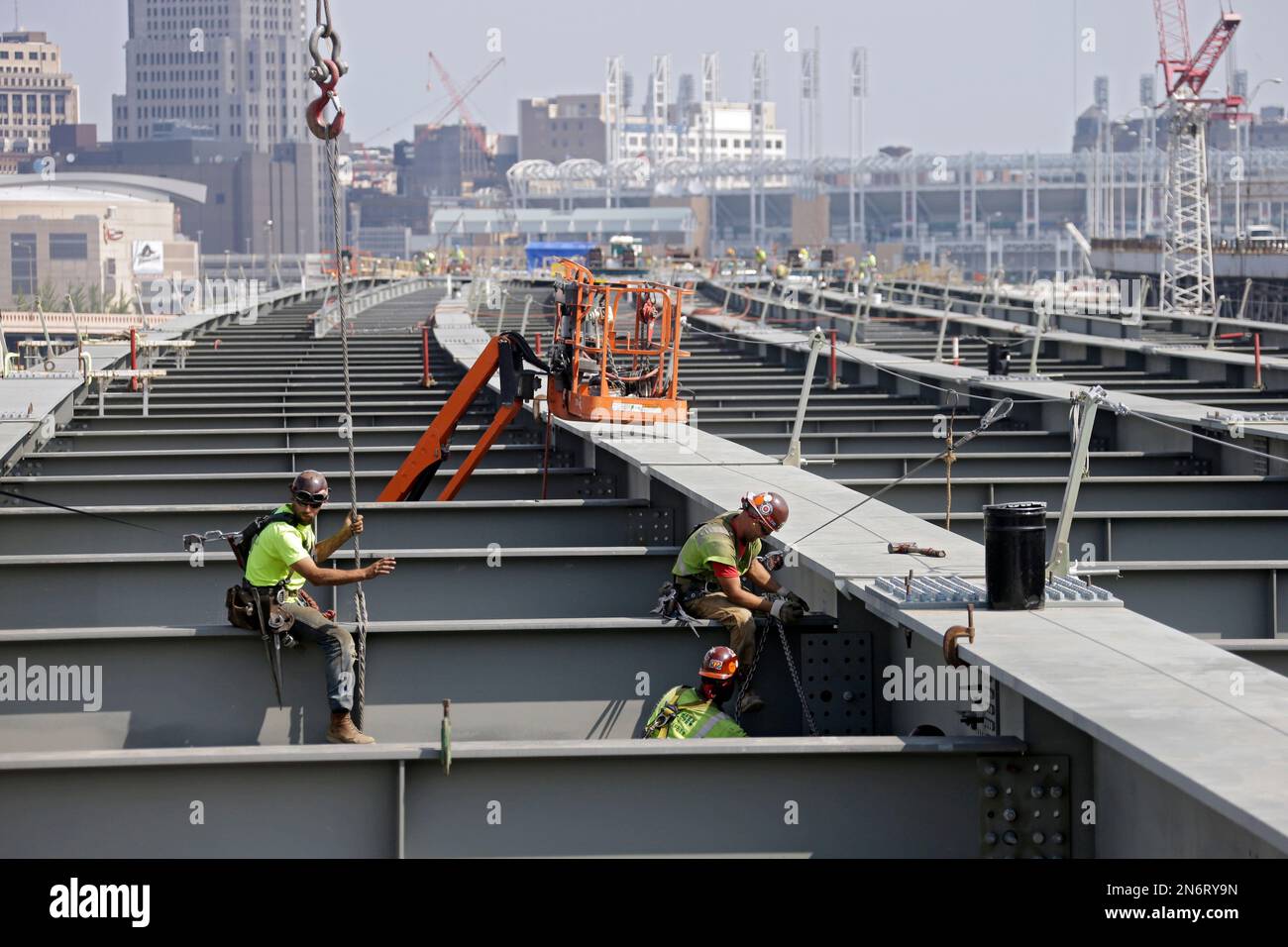 Ironworkers secure a cross member on a highway bridge under ...
