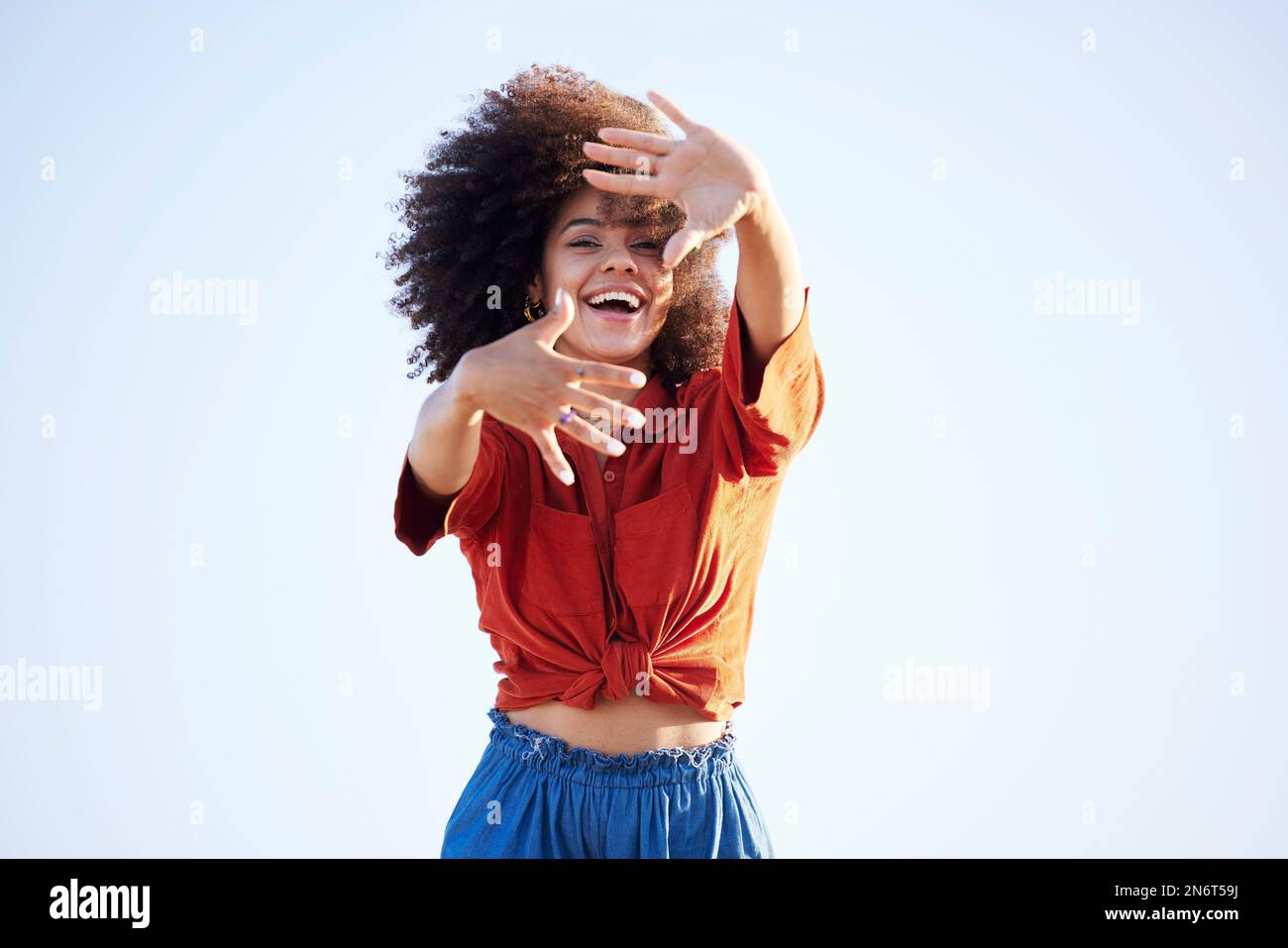 Woman, portrait and hands over face outdoor for fashion on a blue sky ...