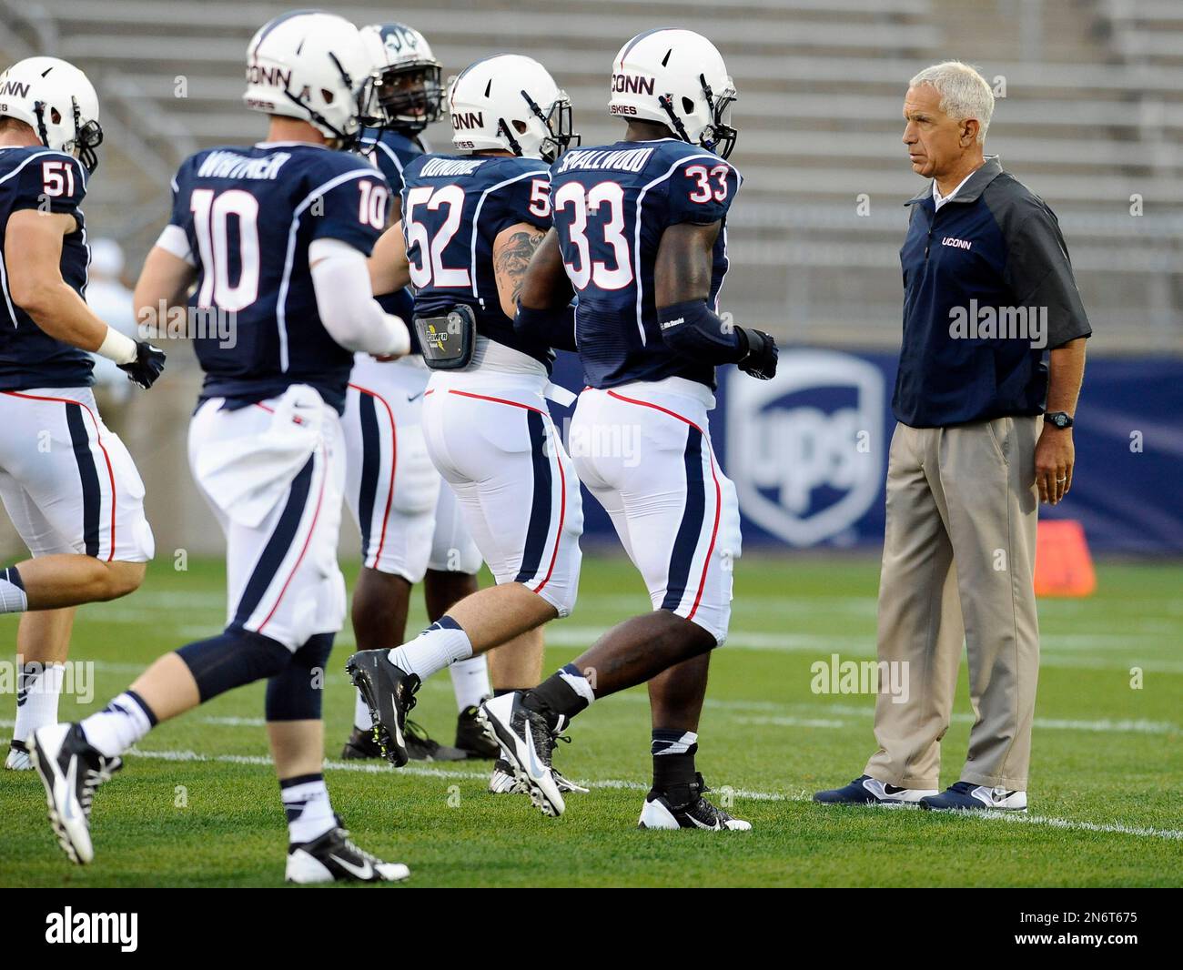 Connecticut head coach Paul Pasqualoni, right, watches his team warm up ...
