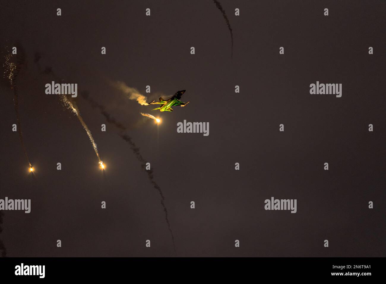 A closeup shot of the Belgian demo F16 dropping flares in the night sky ...