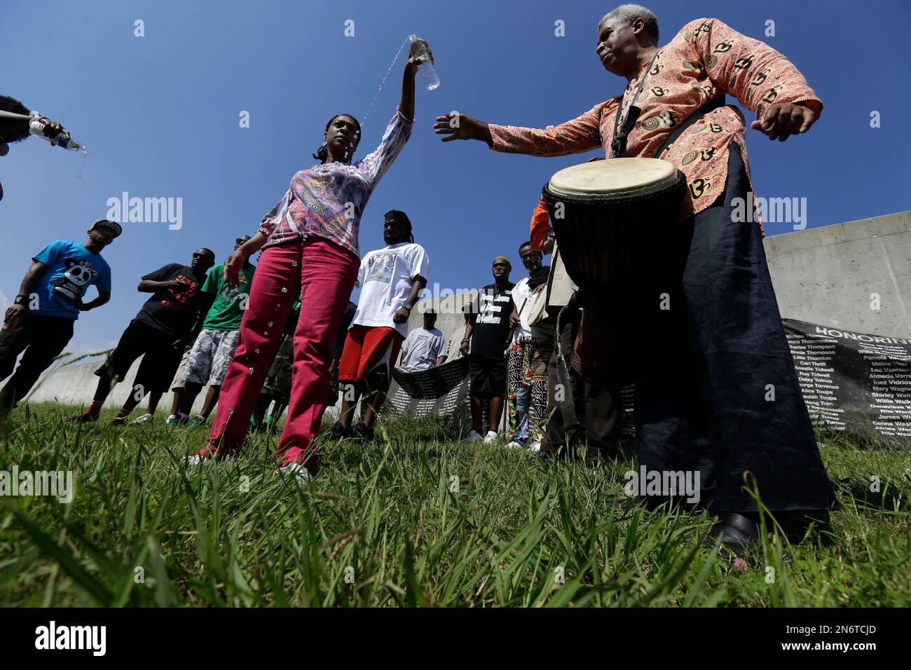 Debra Reed pours water, known as pouring a libation for ancestors, as ...