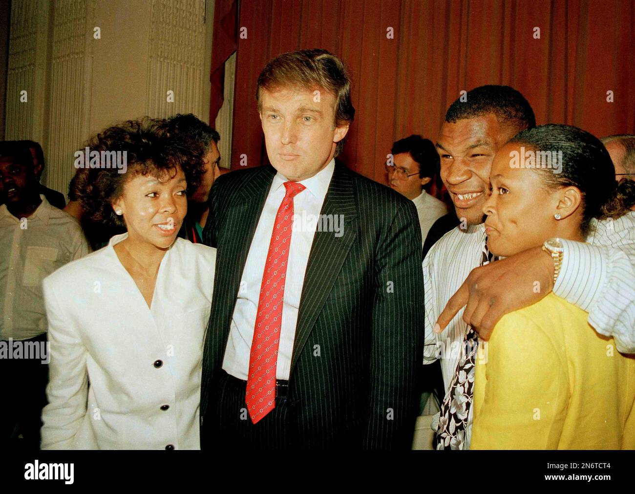 Heavyweight champion Mike Tyson puts an arm around his wife Robin ...