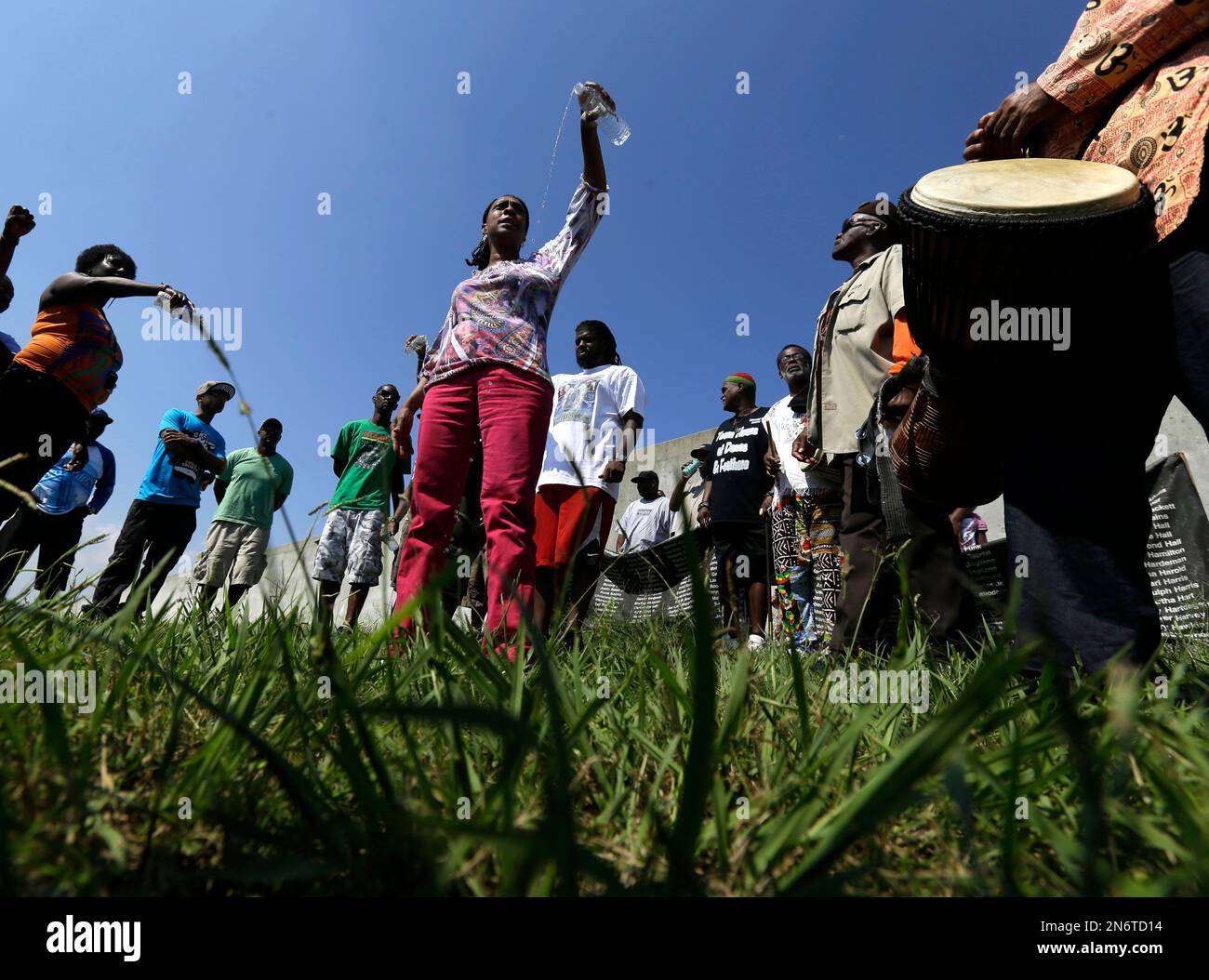 Debra Reed pours water, known as pouring a libation for ancestors, as ...