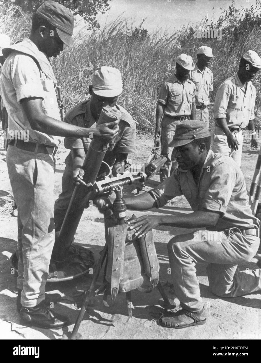 A Frelimo guerrilla unit set up mortar, equipped with shoulder harness ...