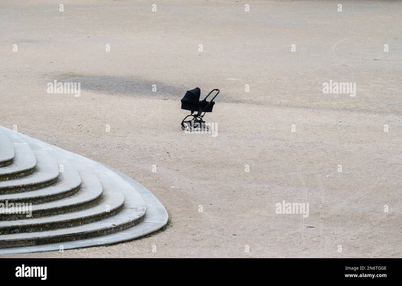 Abandoned pram stading in the sand at the stairs of a park, Nîmes ...