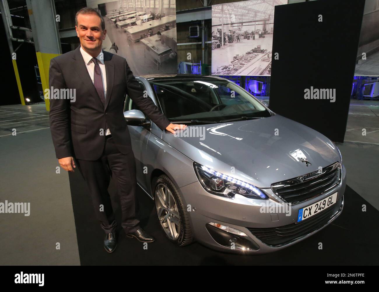 Head of French carmaker Peugoet, Maxime Picat, poses next to the new ...