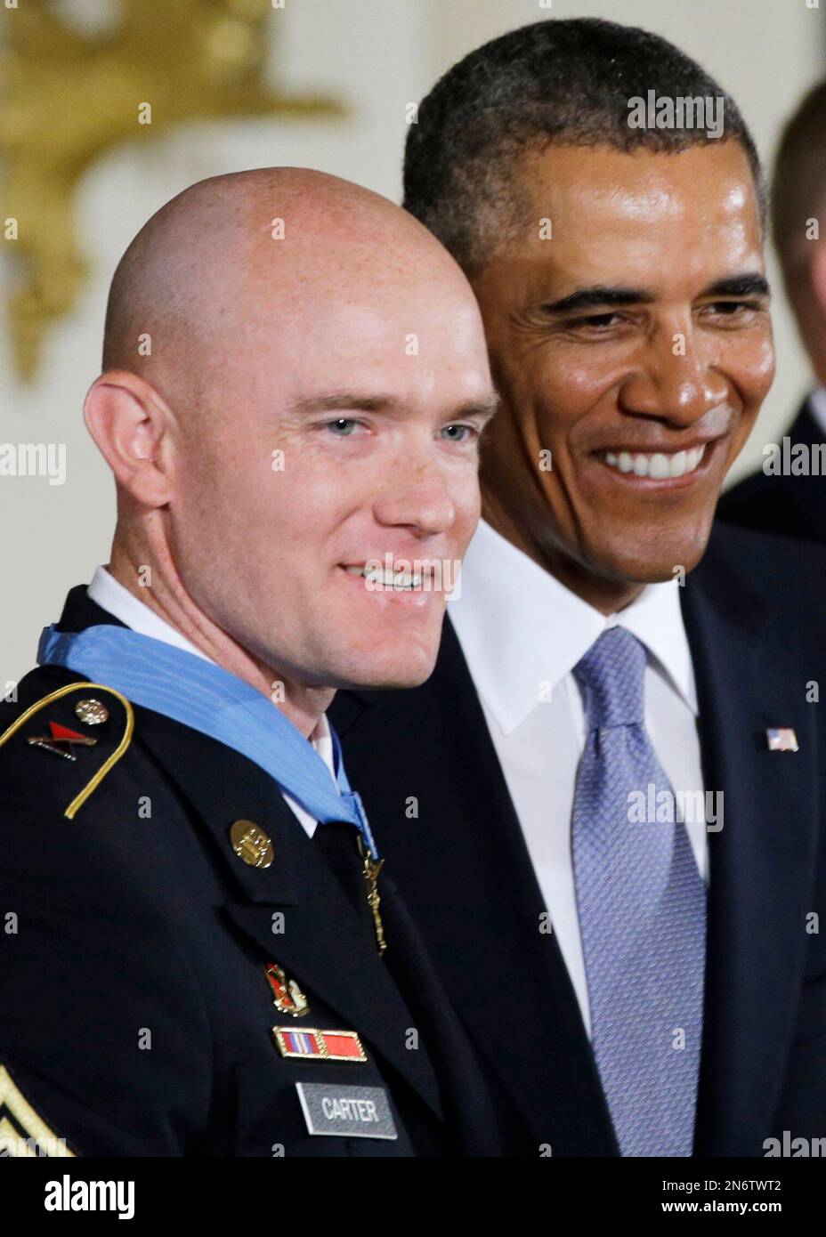 President Barack Obama stands with US Army Staff Sgt. Ty M. Carter ...