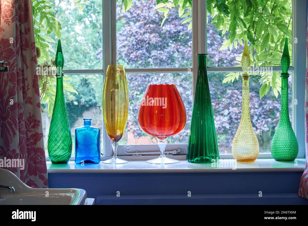 Glass bottles on a window sill Stock Photo - Alamy