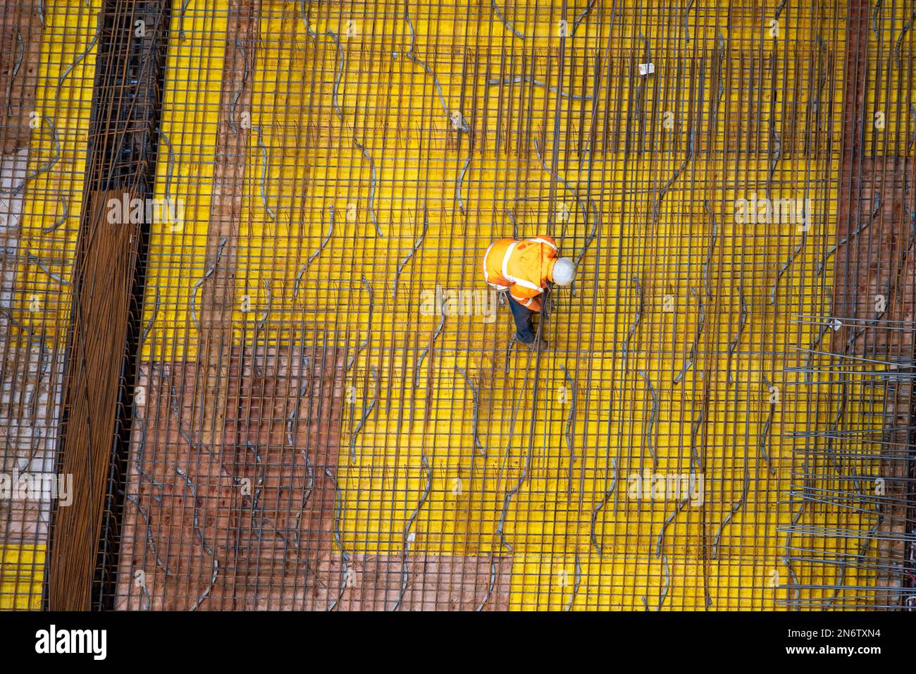 Top view of workers preparing a concrete foundation plate at a ...