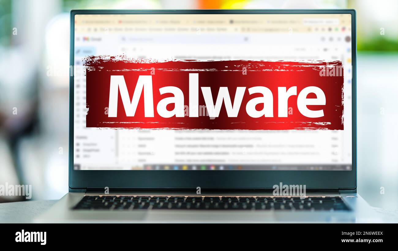 Laptop computer displaying the warning sign of malware on an internet ...
