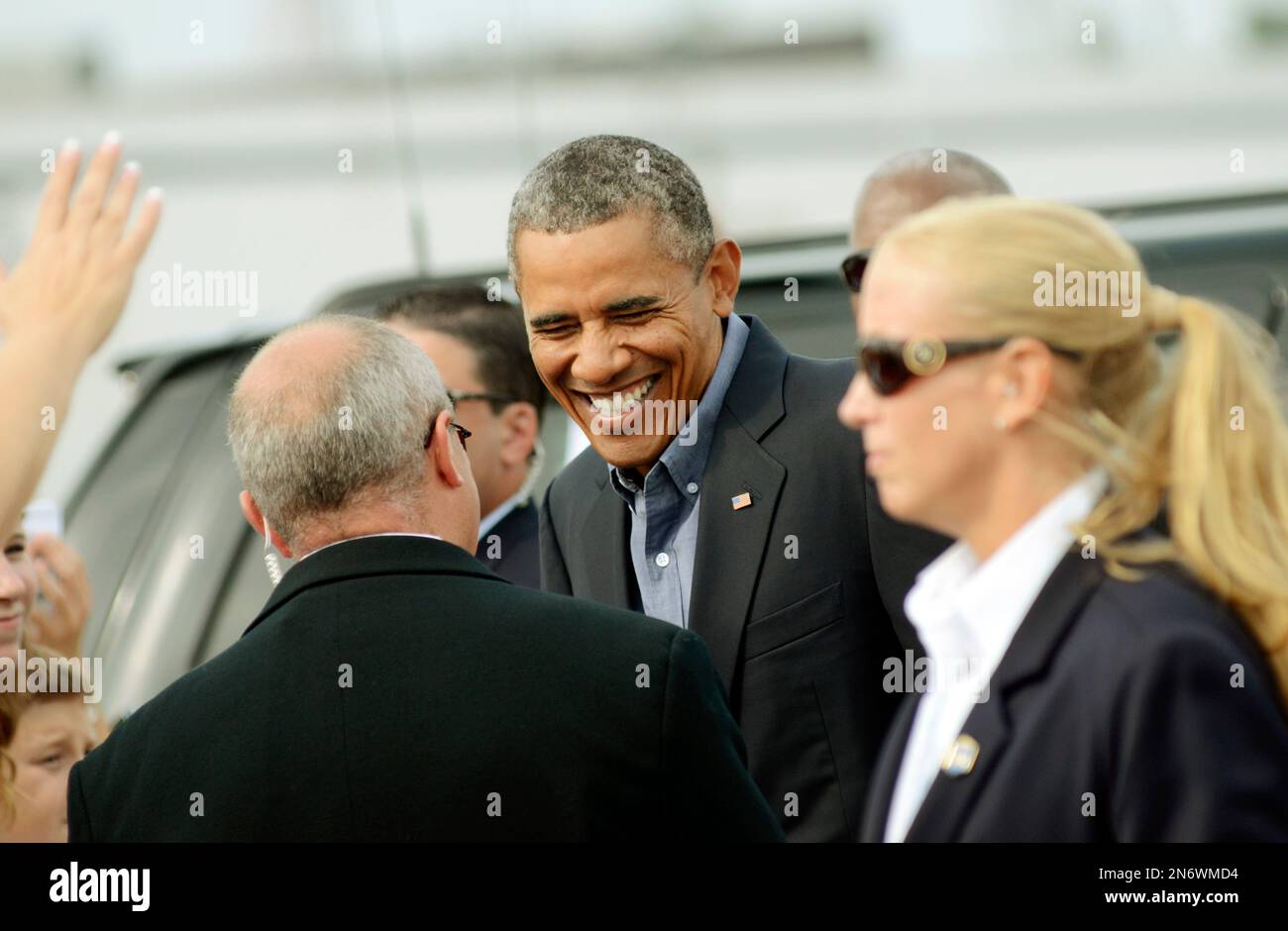 President Barack Obama laughs with an acquintance while making his way ...
