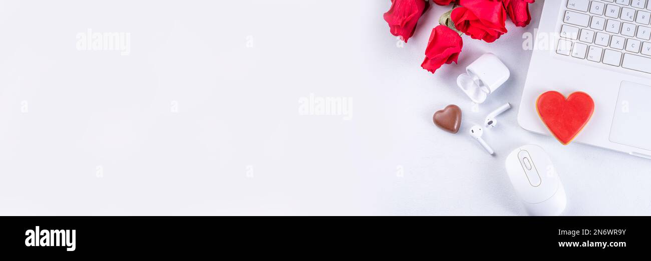 Woman using laptop with red roses. White laptop on white table ...