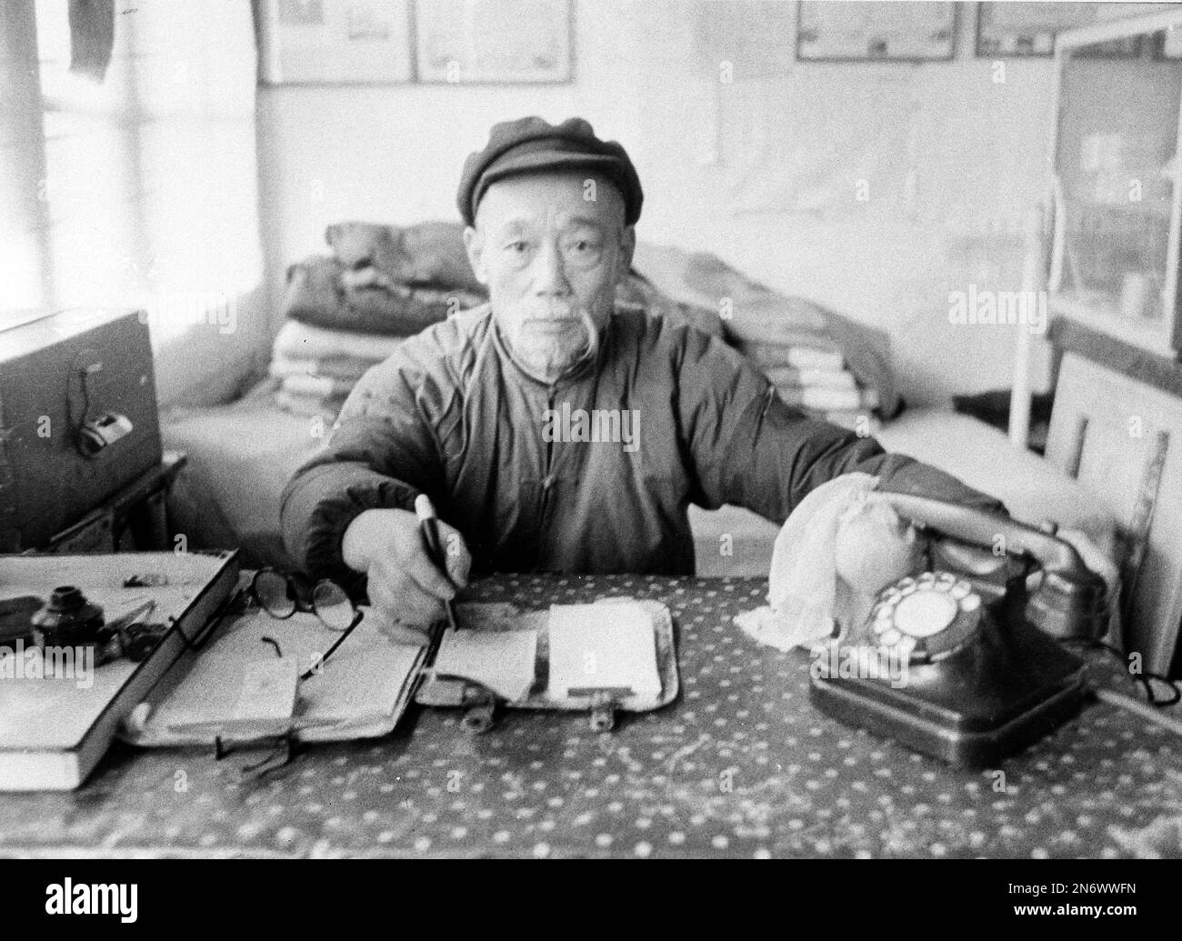 The paymaster at a farming commune in Hangchow, China, is shown in his ...